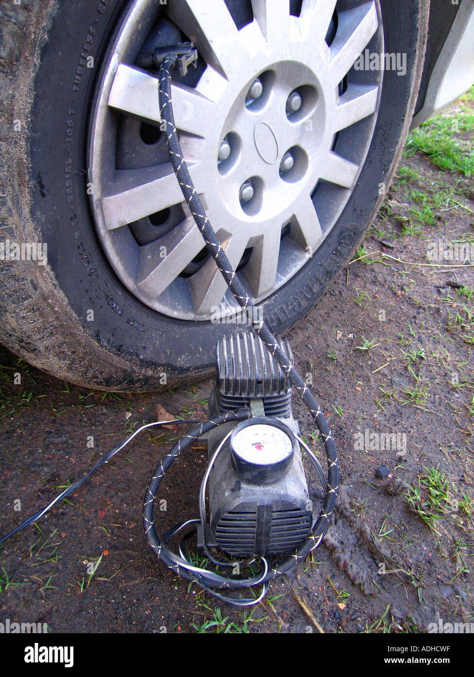Car tyre being inflated with portable 12 volt compressor Stock Photo ...