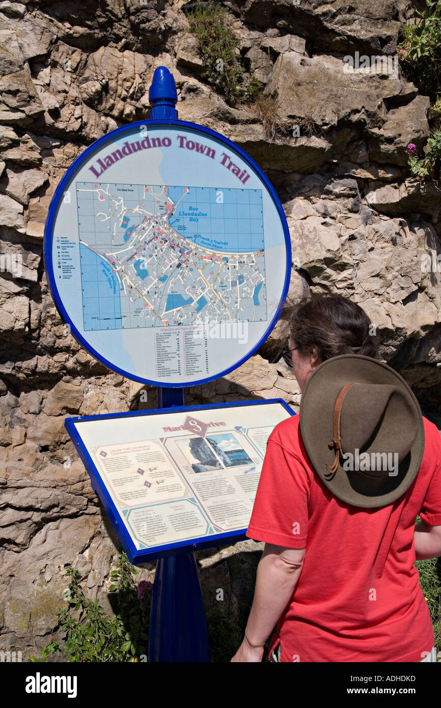 Female tourist reading map and sign about Llandudno Town Trail and ...