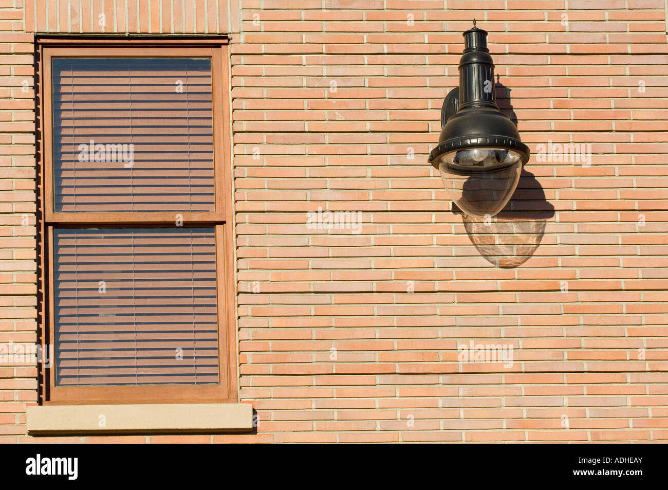 Sunlight illuminates a brick building with a simple window wooden ...