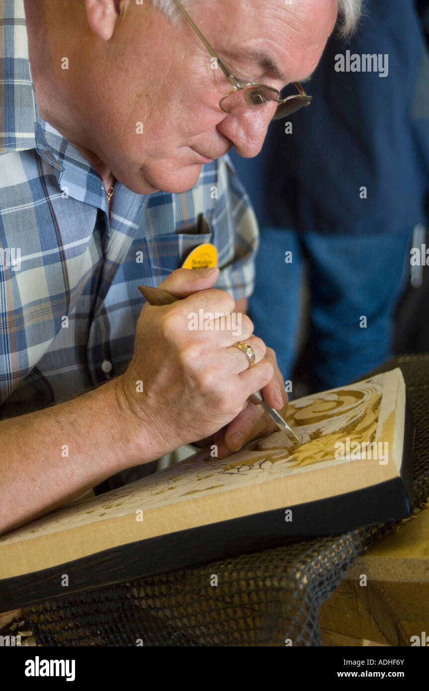 wood carver at wwork on a piece of timber at the yorkshire show, uk ...