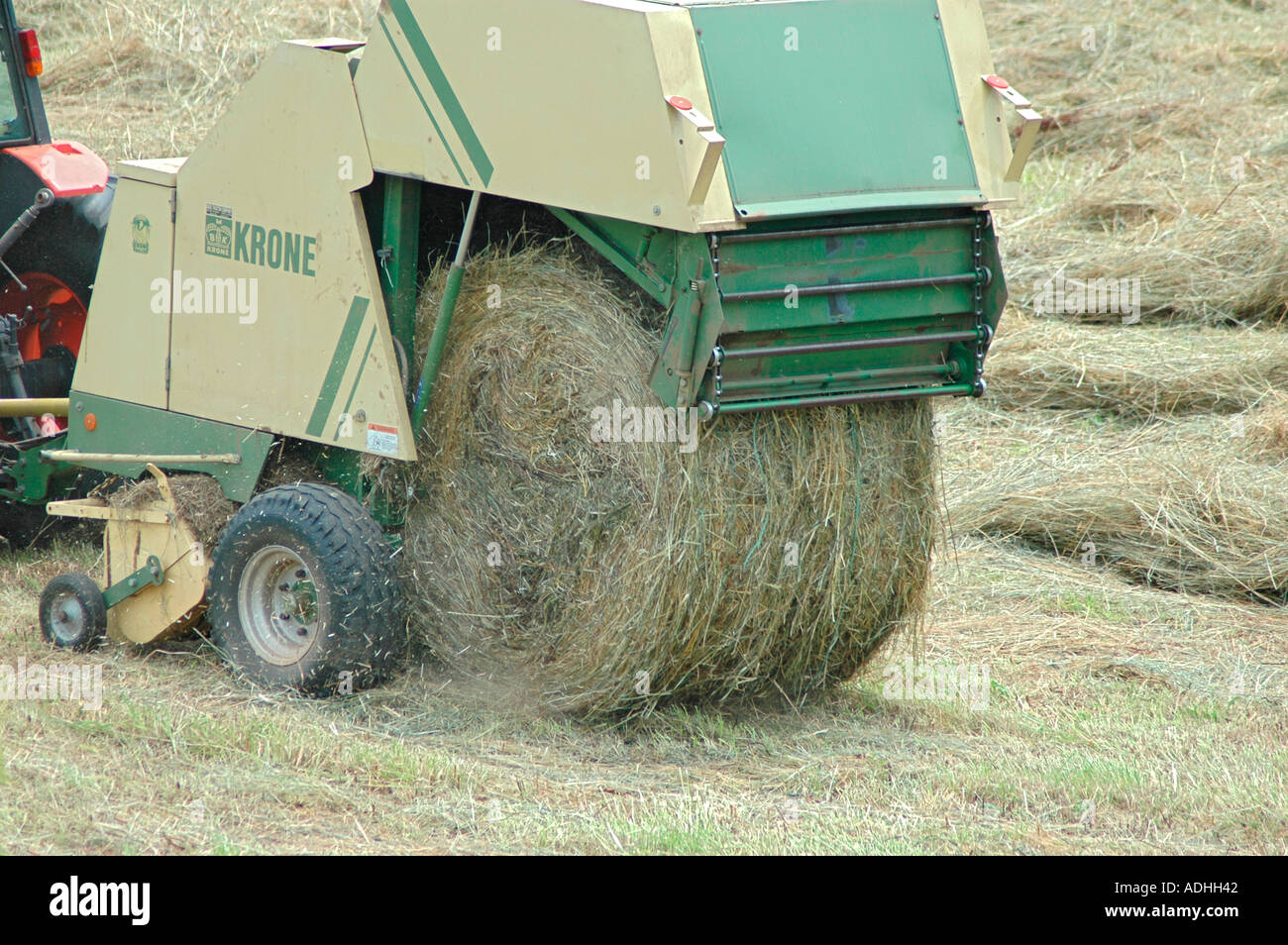 Cutting and rolling hay for animals into roll bales in field Krone ...