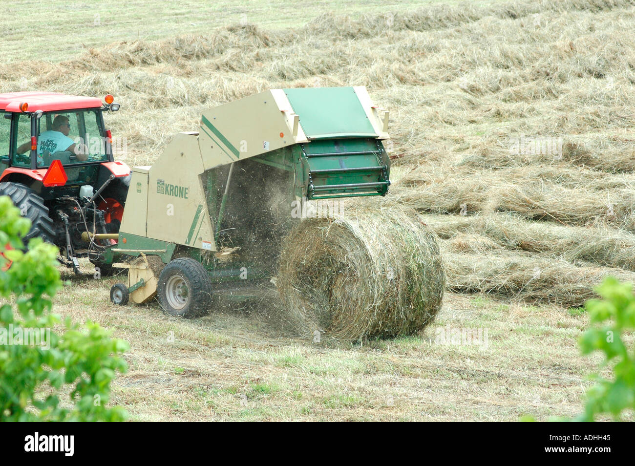 Cutting and rolling hay for animals into roll bales in field Krone ...