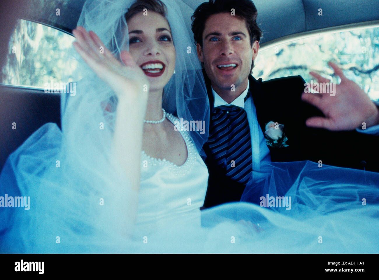Newlywed couple waving from inside a car Stock Photo - Alamy