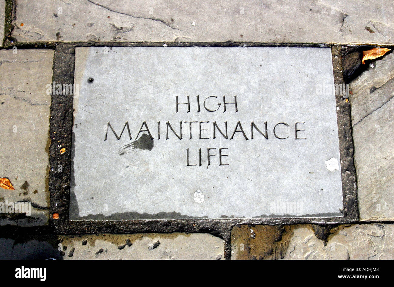 Text on pavement reading High Maintenance Life Stock Photo - Alamy