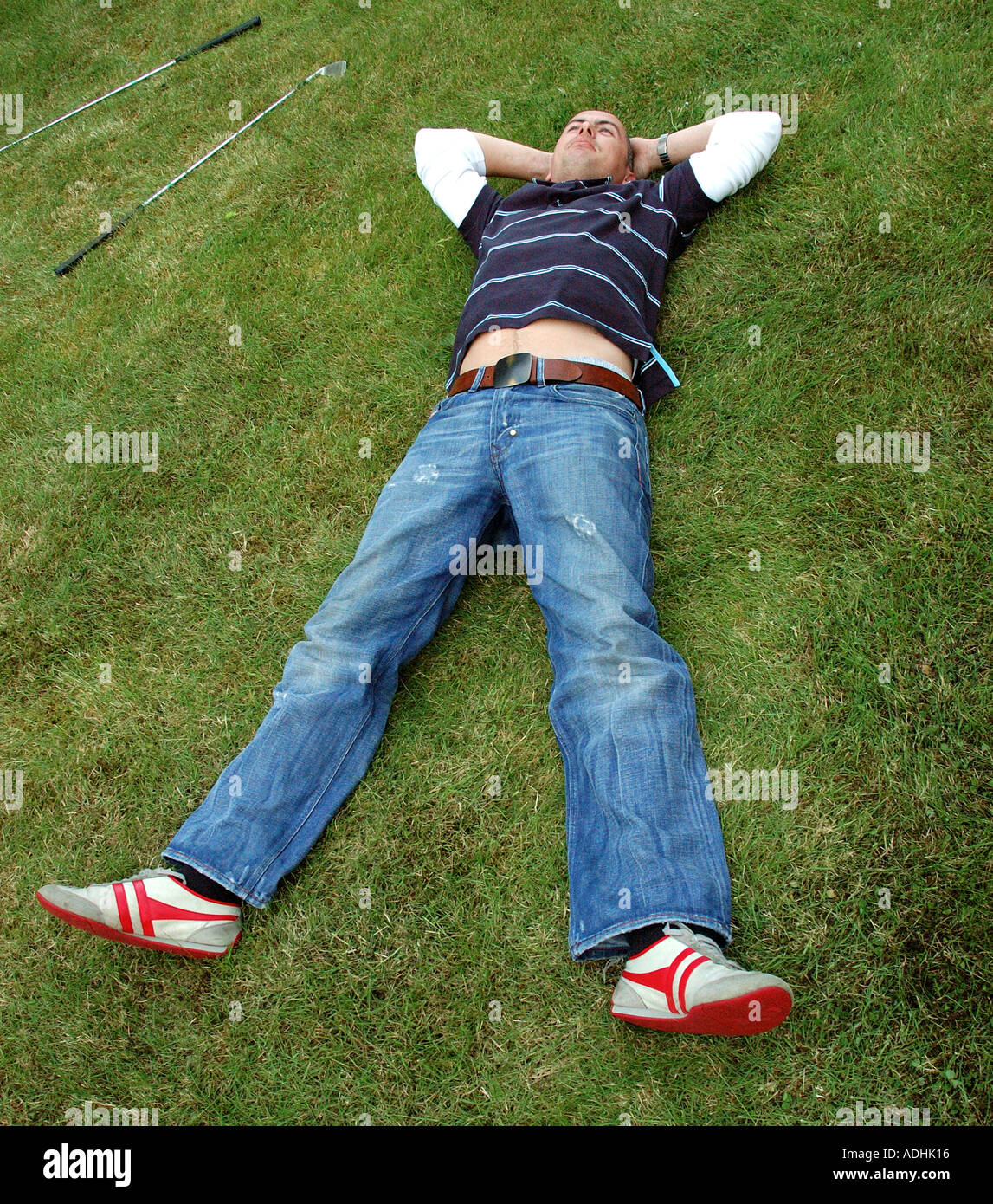man in jeans laying on the lawn Stock Photo - Alamy