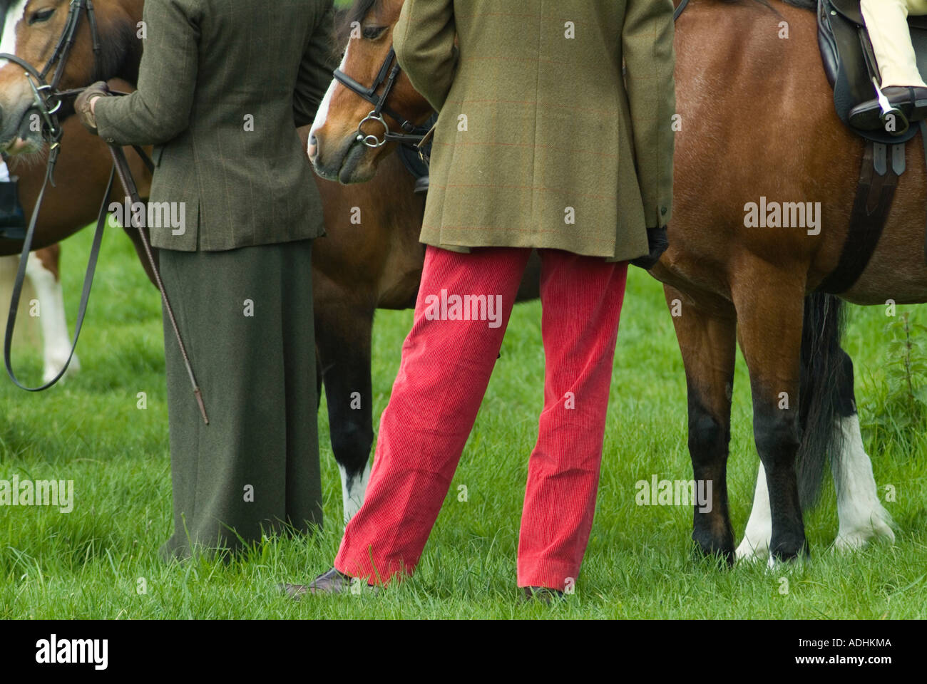 detail of parents standing holding reins of children on ponies at ...