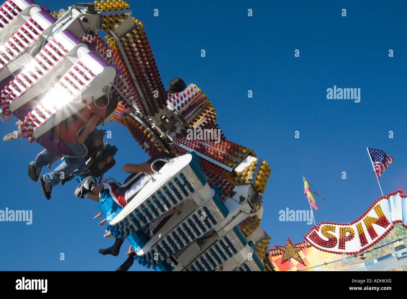 People of all ages enjoying the thrill of a whirling, spinning ride at ...