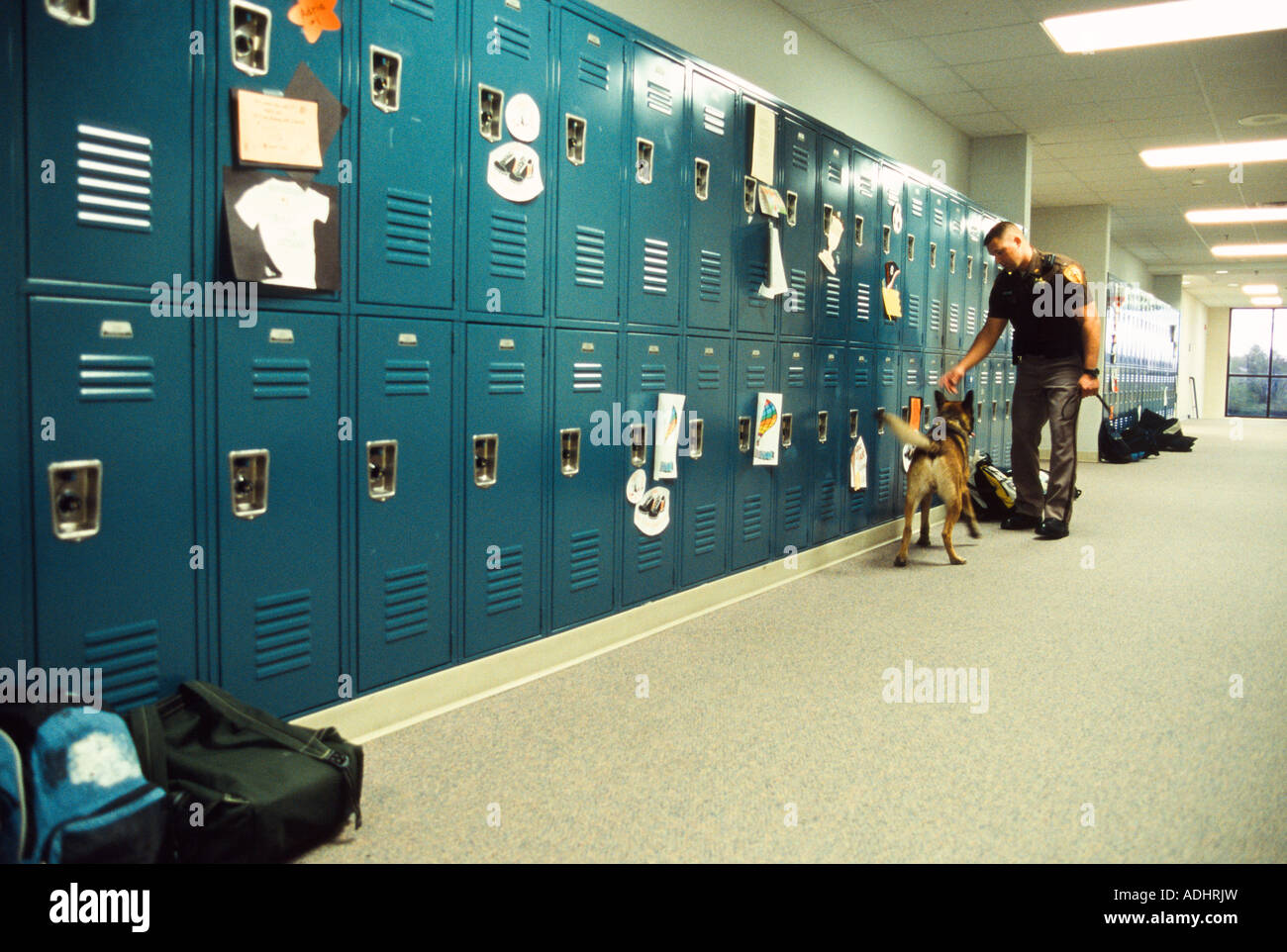 Sergeant with K-9 checking bags and lockers in US high school. Nebraska ...