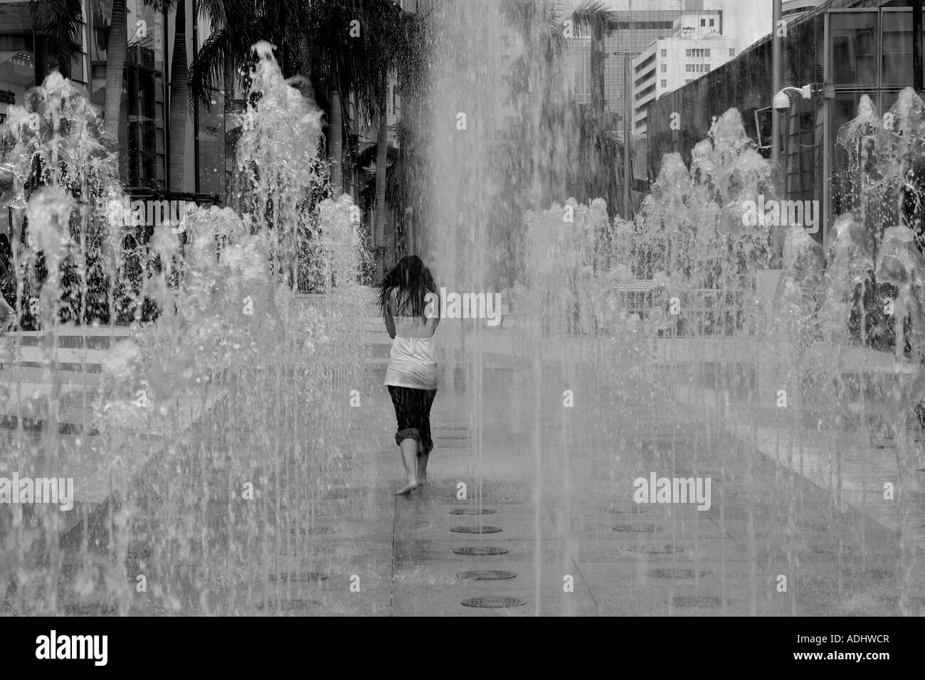 Lading walking through a water fountain Stock Photo - Alamy