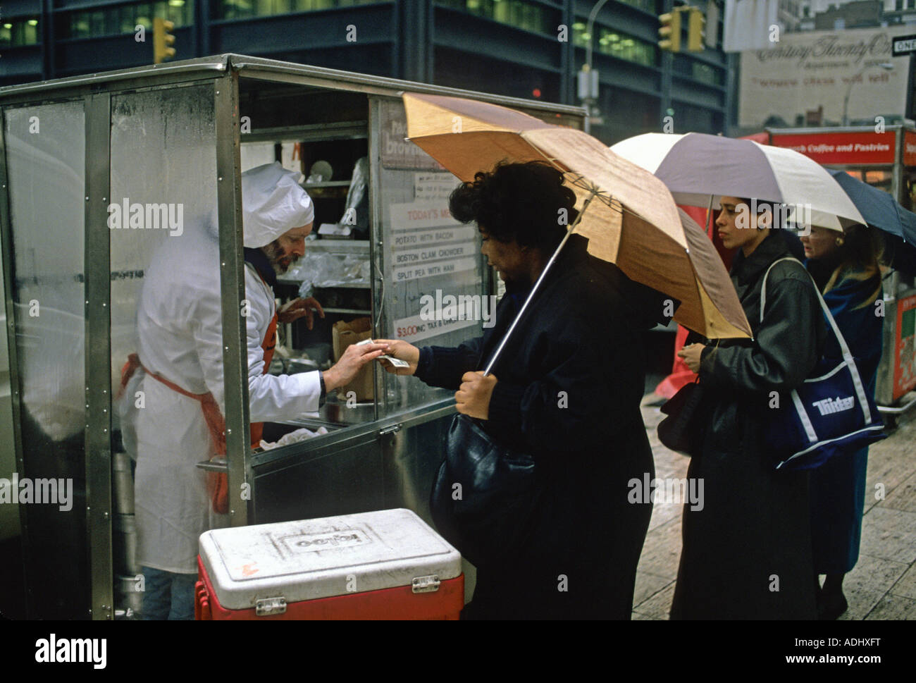 Customers buying their lunch from a kitchen on wheel at the corner of ...