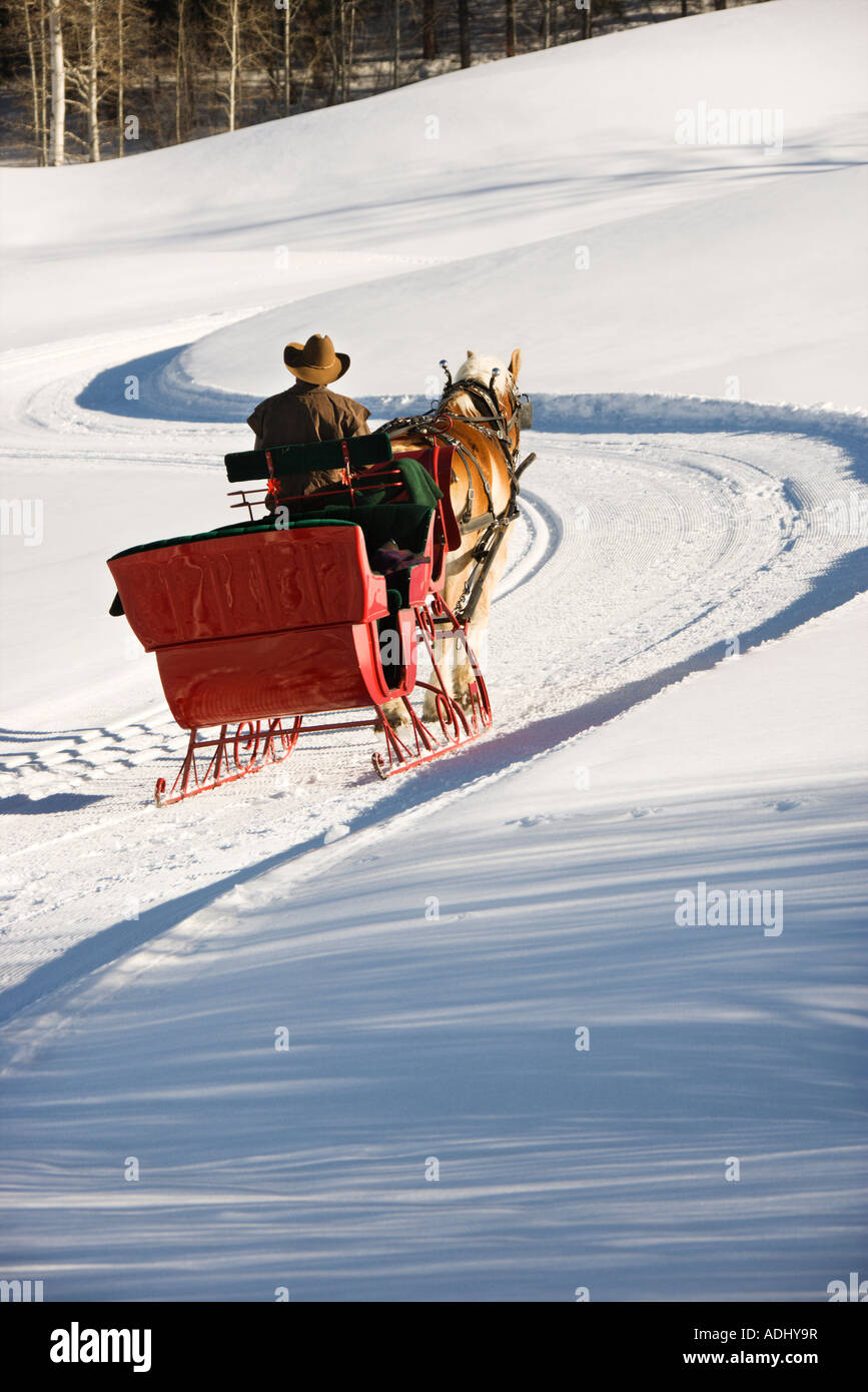 Man driving sleigh up a snow covered hill Stock Photo - Alamy