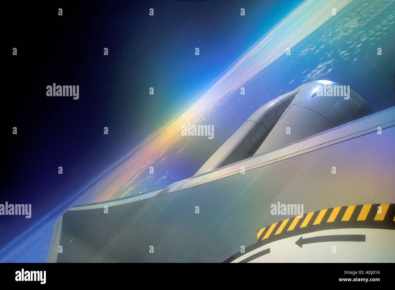 Airplane window view of wing and jet engine with clouds and sun shining ...