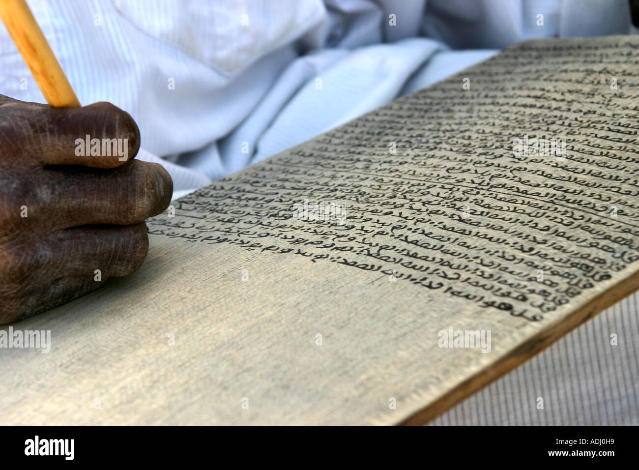 Muslim man in Chad writing out Qur`anic verses on a board Stock Photo ...