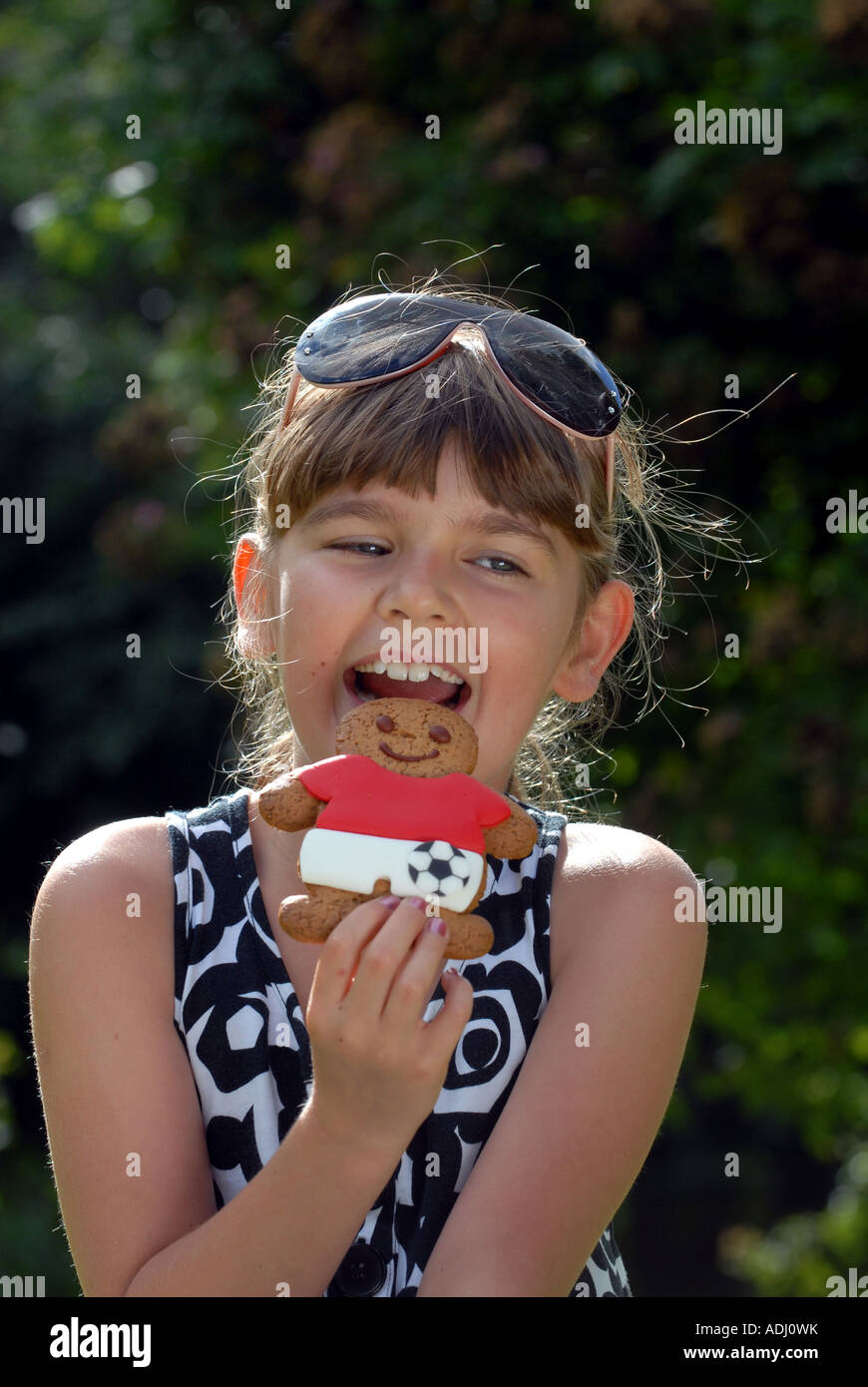 Young girl eating Market Drayton gingerbread man, Shropshire, England ...