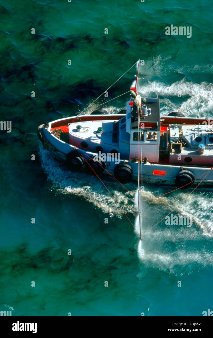 Boat spraying Oil Slick Stock Photo - Alamy