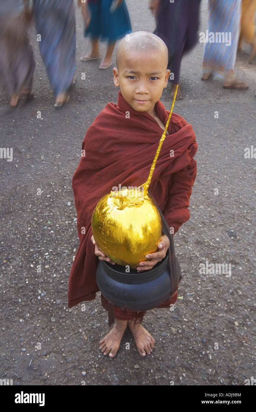 Little monk holding a gold leaf wrapped coconut as offering Yangon ...