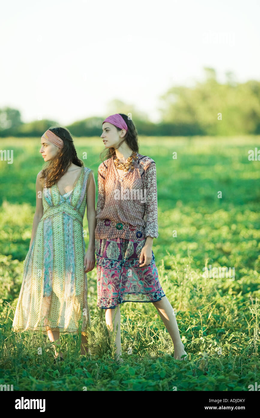 Young hippie women standing in field, looking away, full length Stock ...
