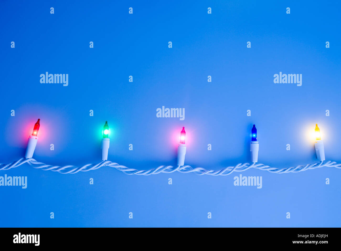 One white strand of multi colored Christmas tree lights on white ...