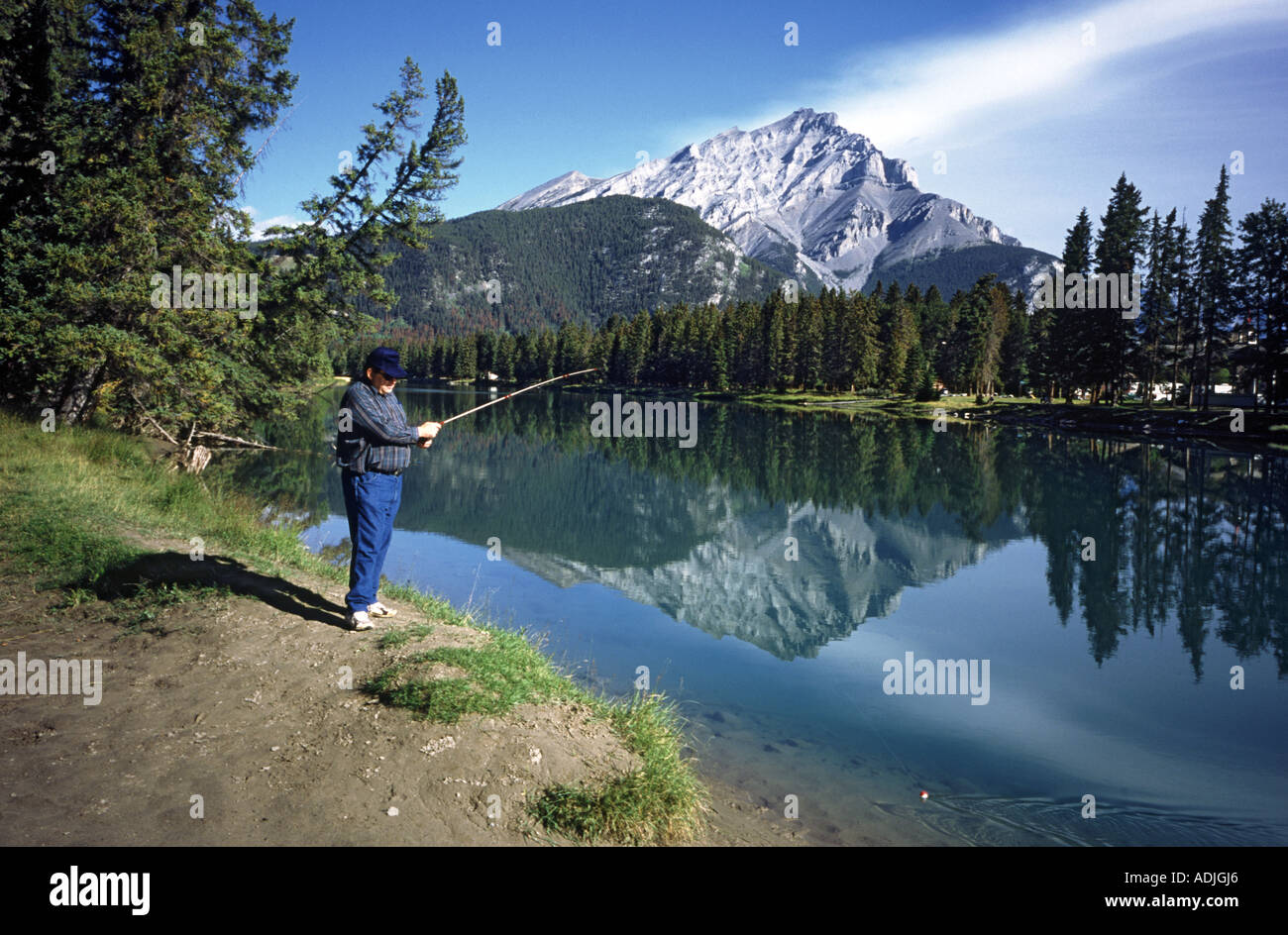 Man fishing Bow river with Cascade Mountain reflection Banff National ...