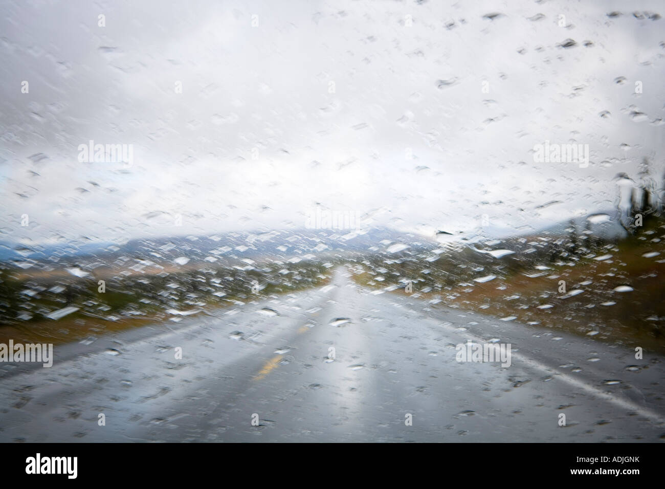 Drivers view of rain covered windshield and roadway with blurred motion ...