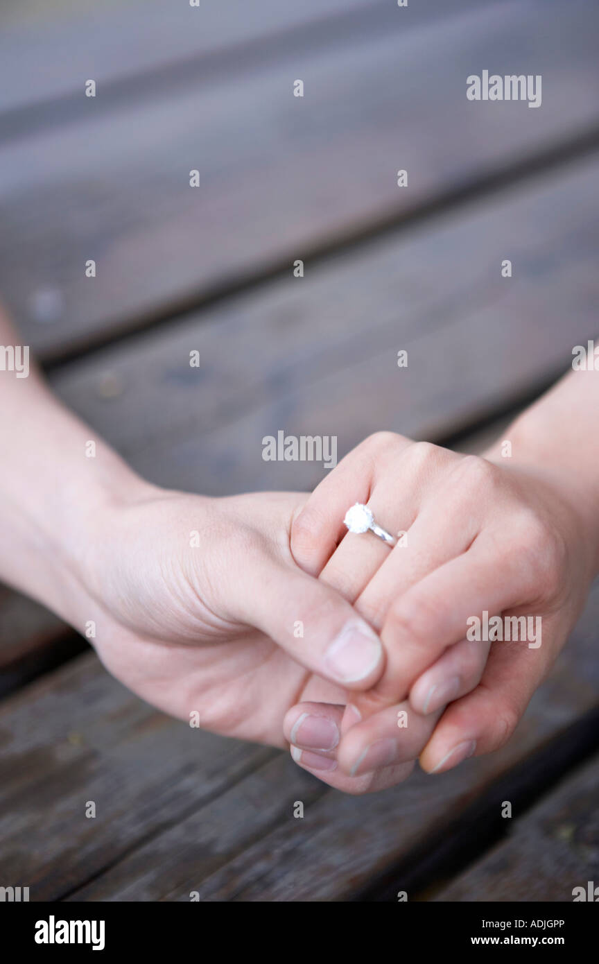man holding hands with woman with wedding band Stock Photo - Alamy