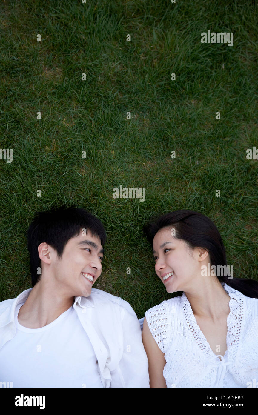 rest grass field facing each other happy merry couple Stock Photo - Alamy