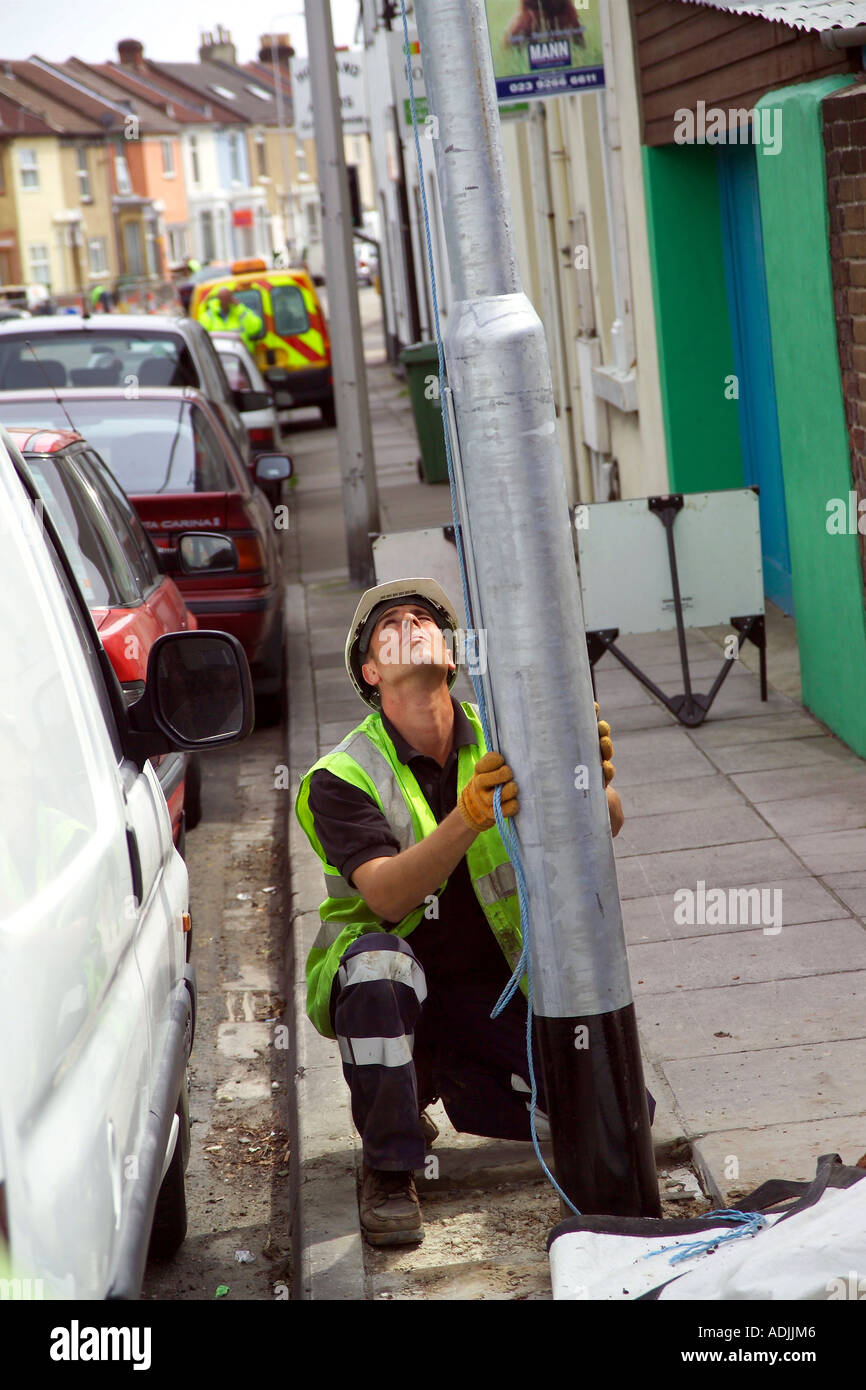 Workman fitting new lamp post in residential street Stock Photo - Alamy