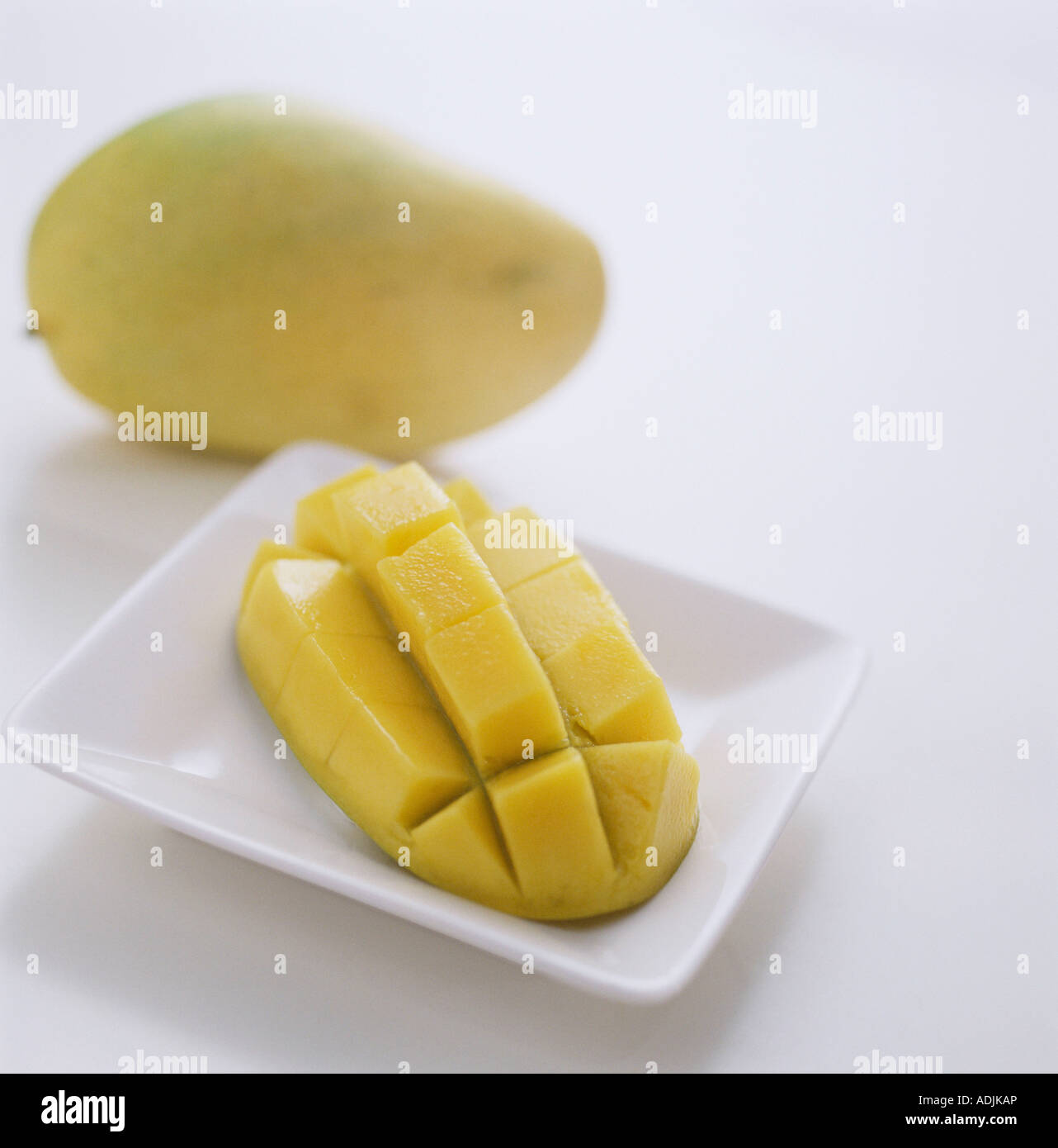 Cut mango on the plate and a mango Stock Photo - Alamy
