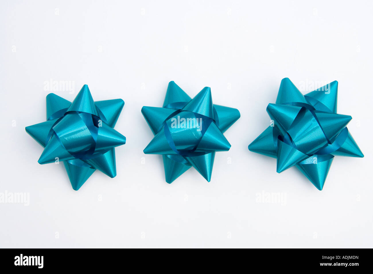 Three bright blue Christmas gift bows in row on white background studio ...