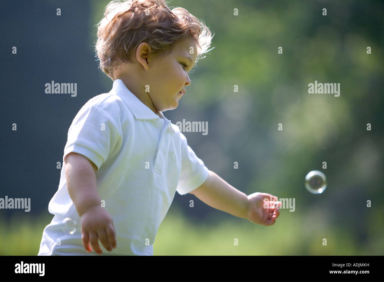 Little boy catching a bubble in the parc Stock Photo - Alamy