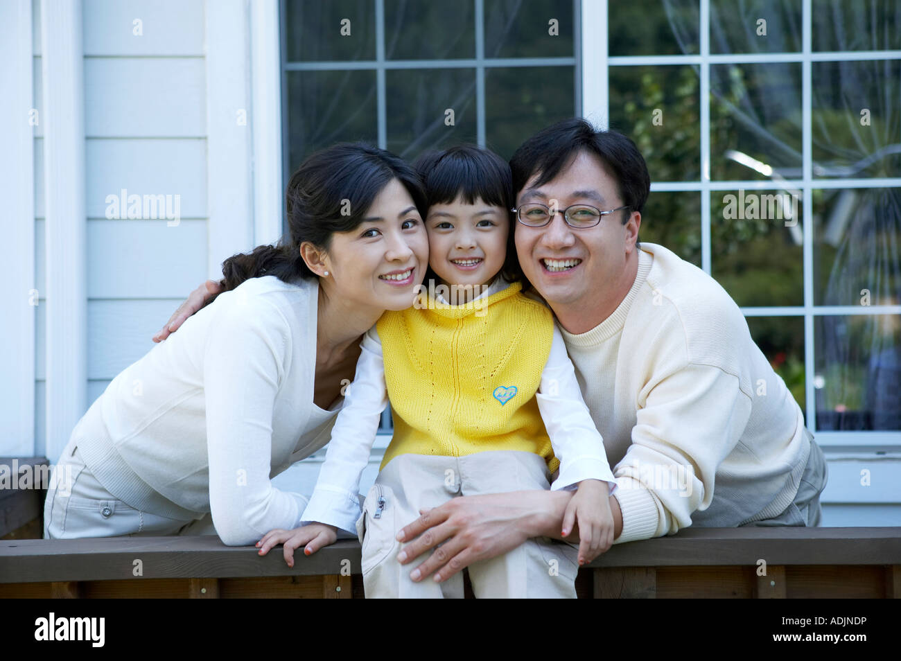 A Korean family standing in front of their house with a smile Stock ...