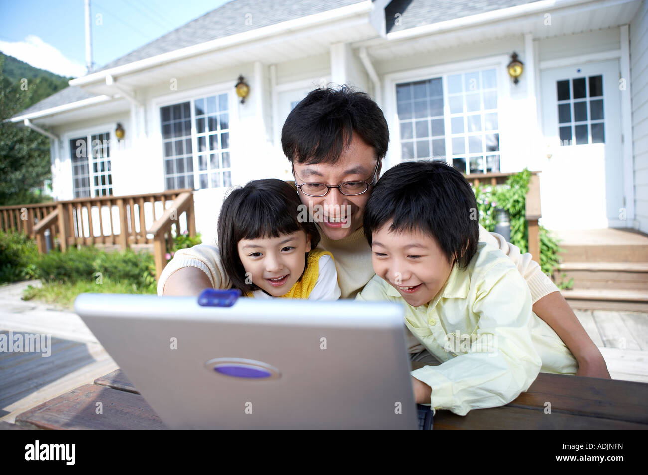 A Korean father and his children watching a notebook computer Stock ...