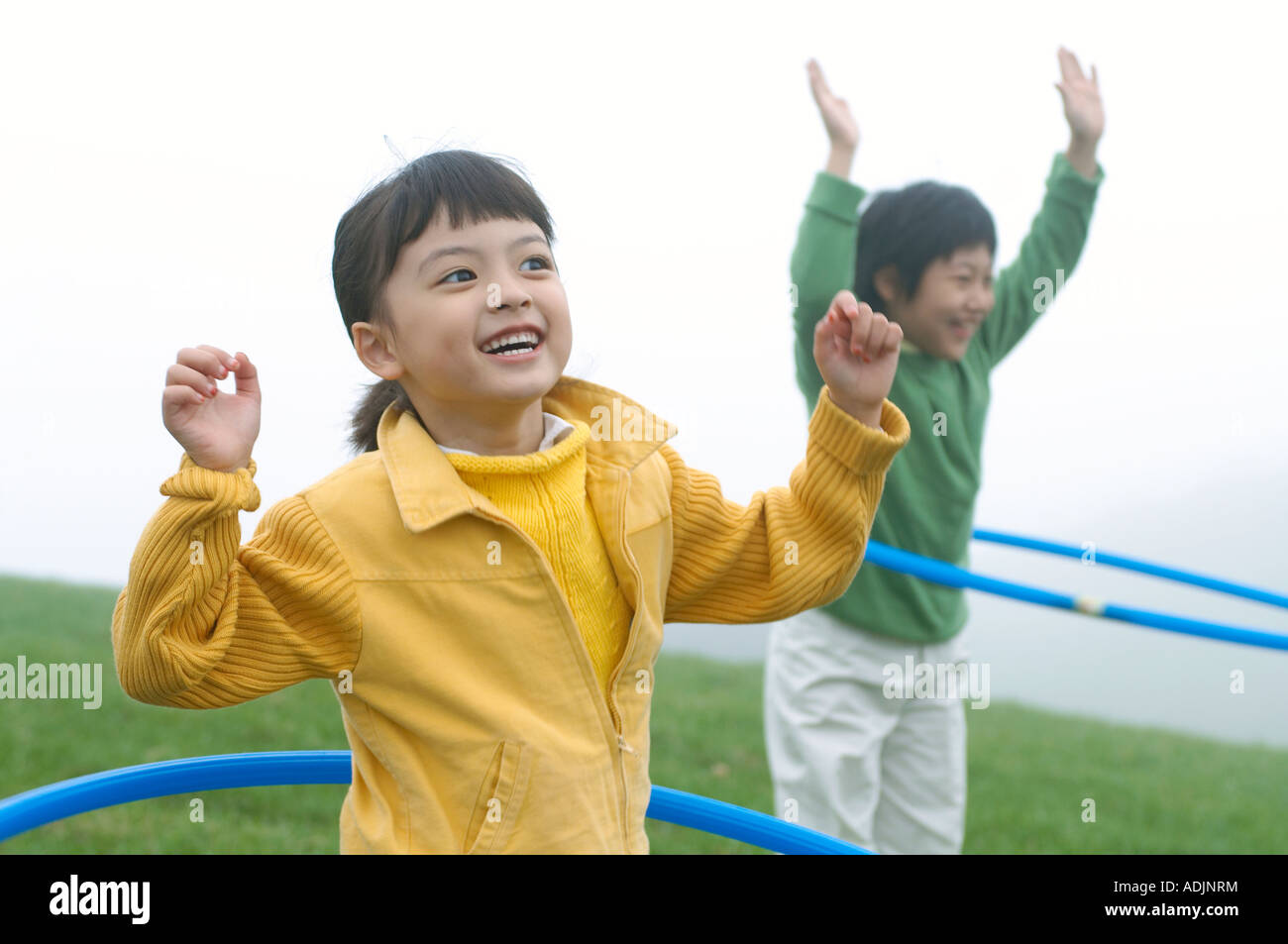 A Korean brother and sister hula hooping with a smile Stock Photo - Alamy