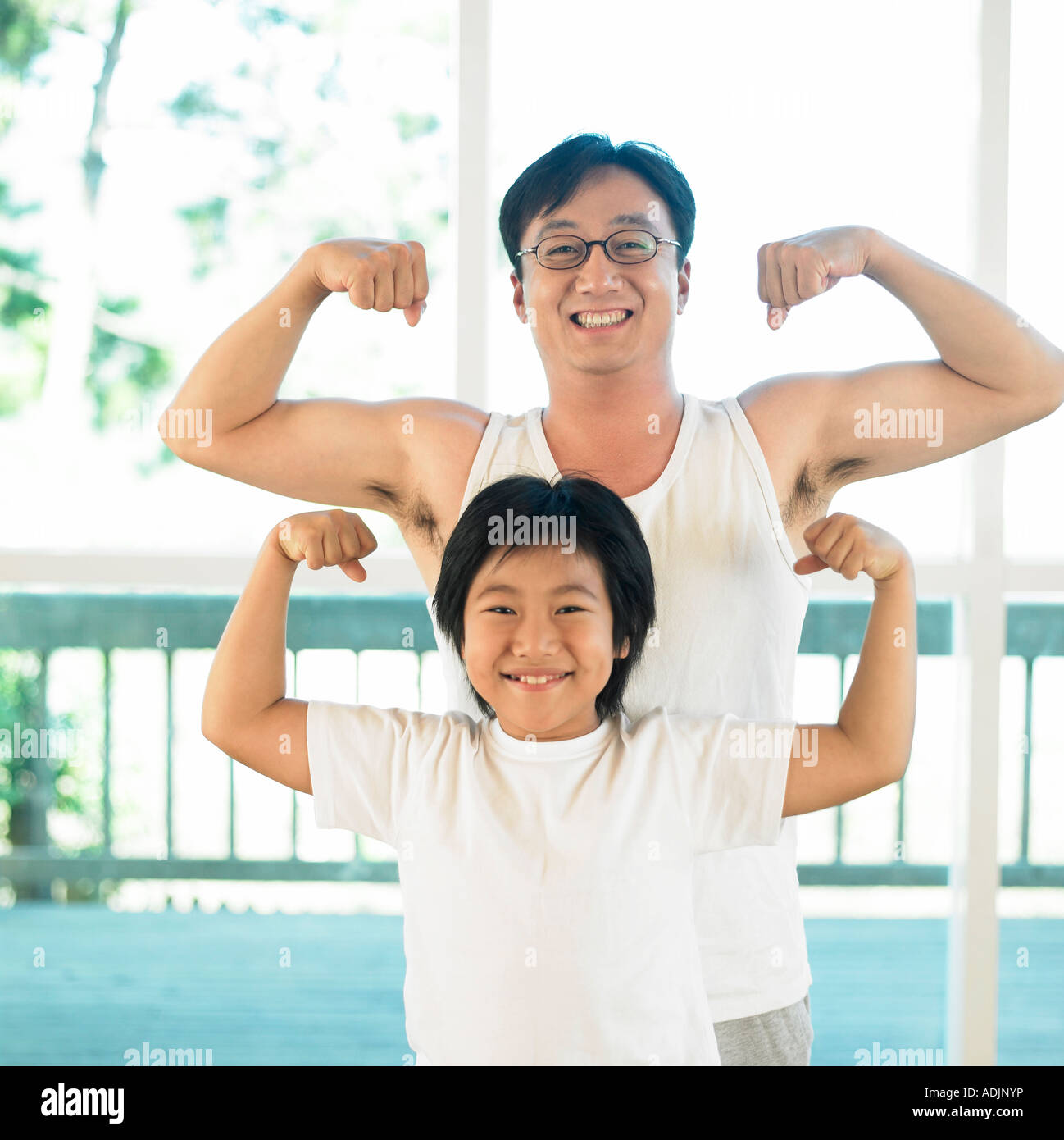 A Korean father and a son are sowing their muscle with a smile Stock ...