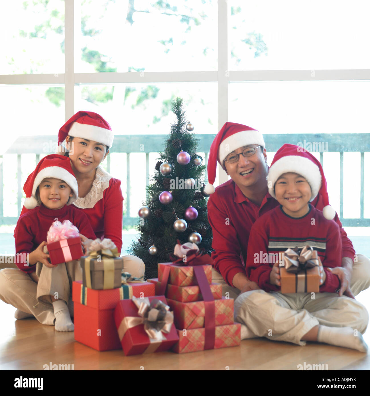 A Korean family is putting on a Santa Claus's hat and sitting by the ...