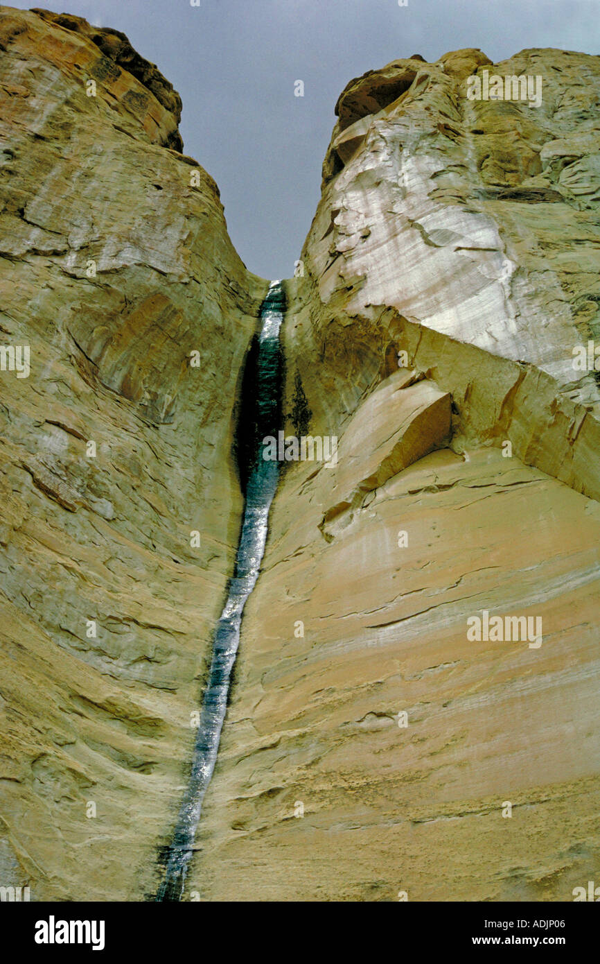 A silver streak of water streams down from the top a mountain peak ...