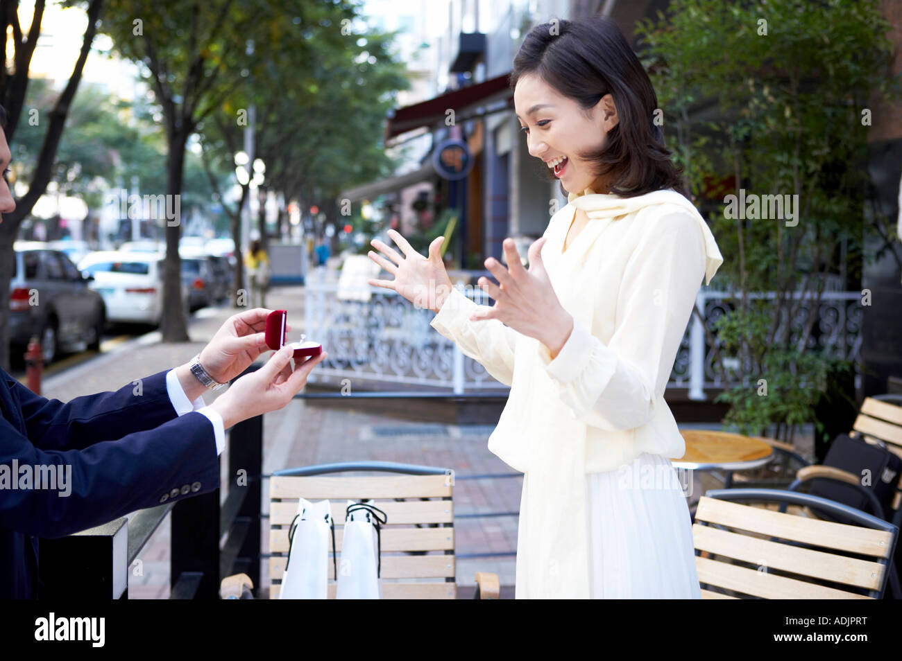 A man is giving a ring to a smiling woman Stock Photo - Alamy