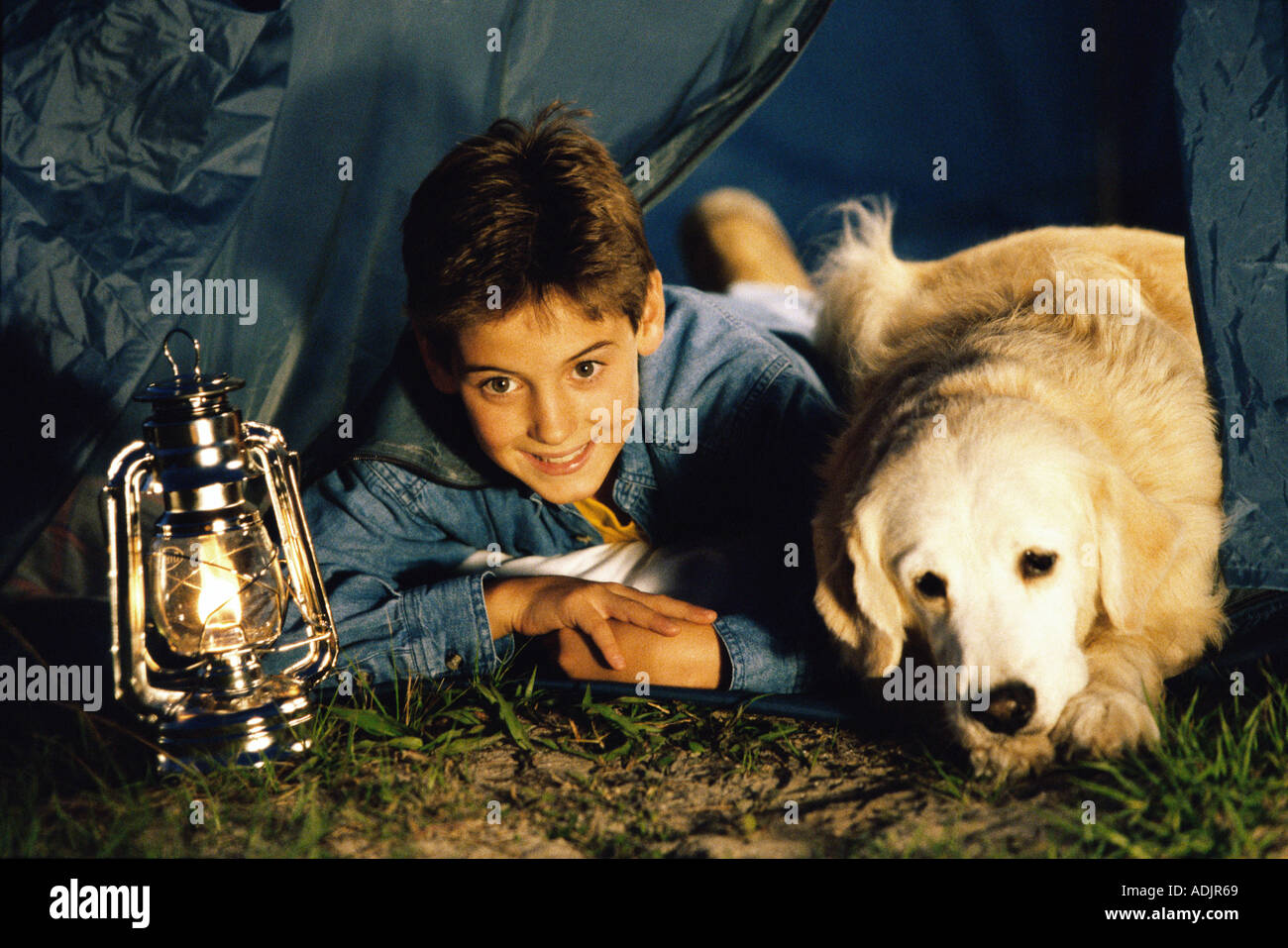 Boy camping in a tent with his dog Stock Photo - Alamy