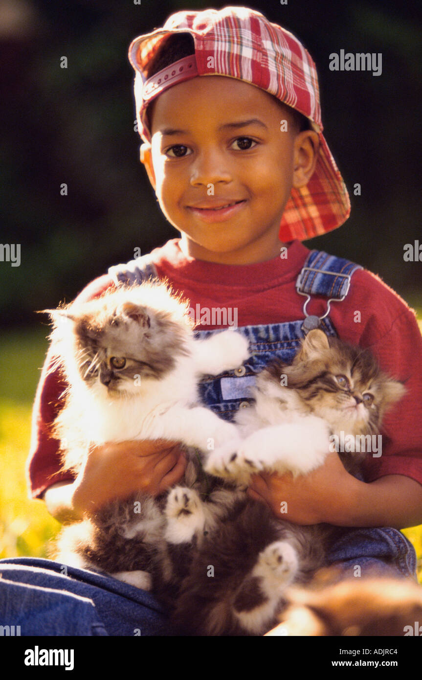 Portrait of a boy holding cats Stock Photo - Alamy