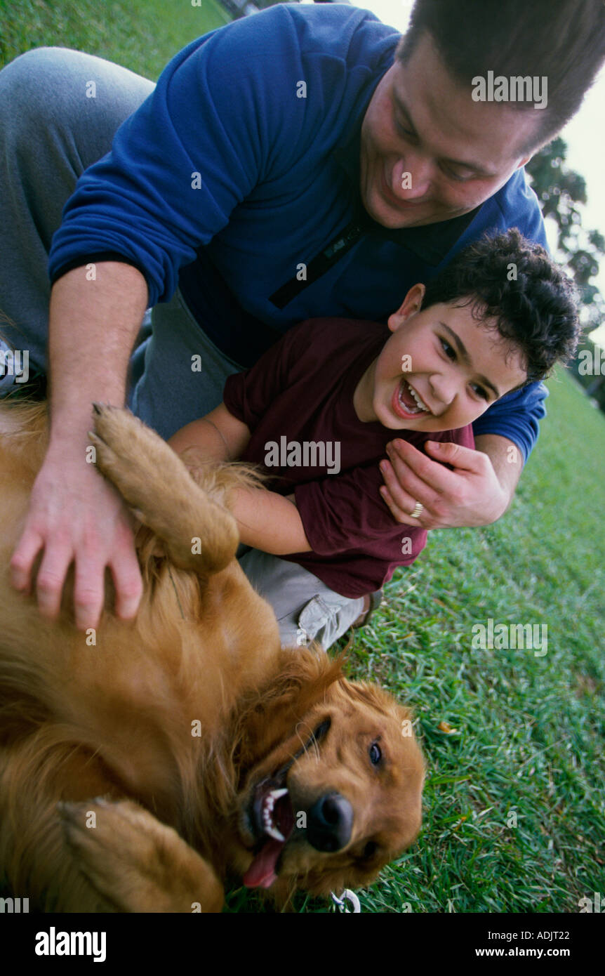 Father and his son playing with their dog Stock Photo - Alamy