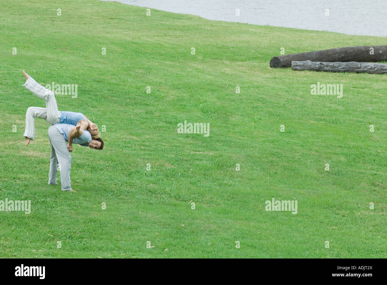 Man bending over with woman on back, on lawn Stock Photo - Alamy