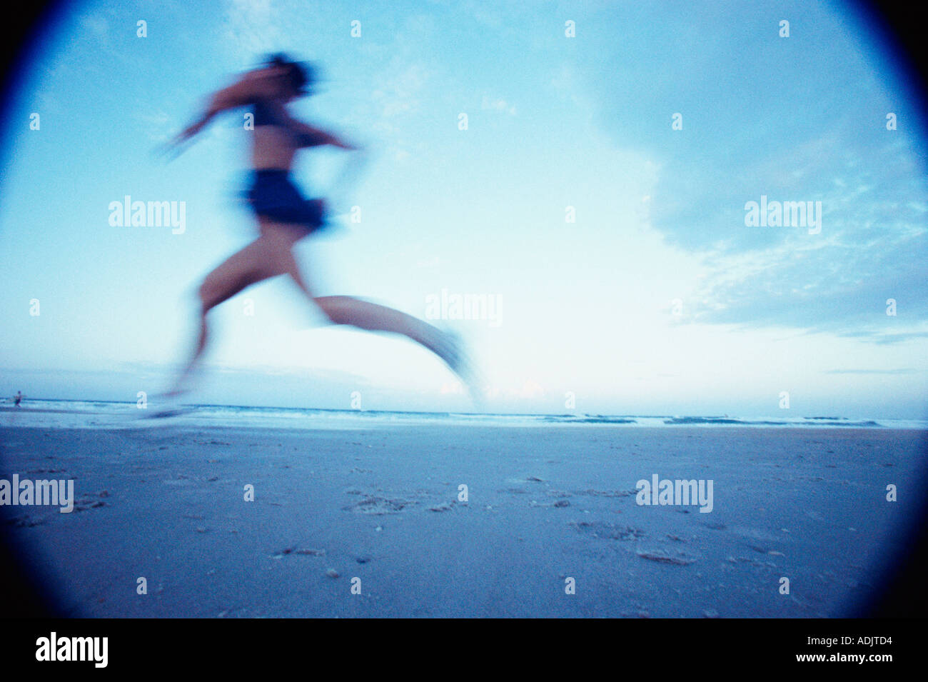 Side profile of a woman running on the beach Stock Photo - Alamy