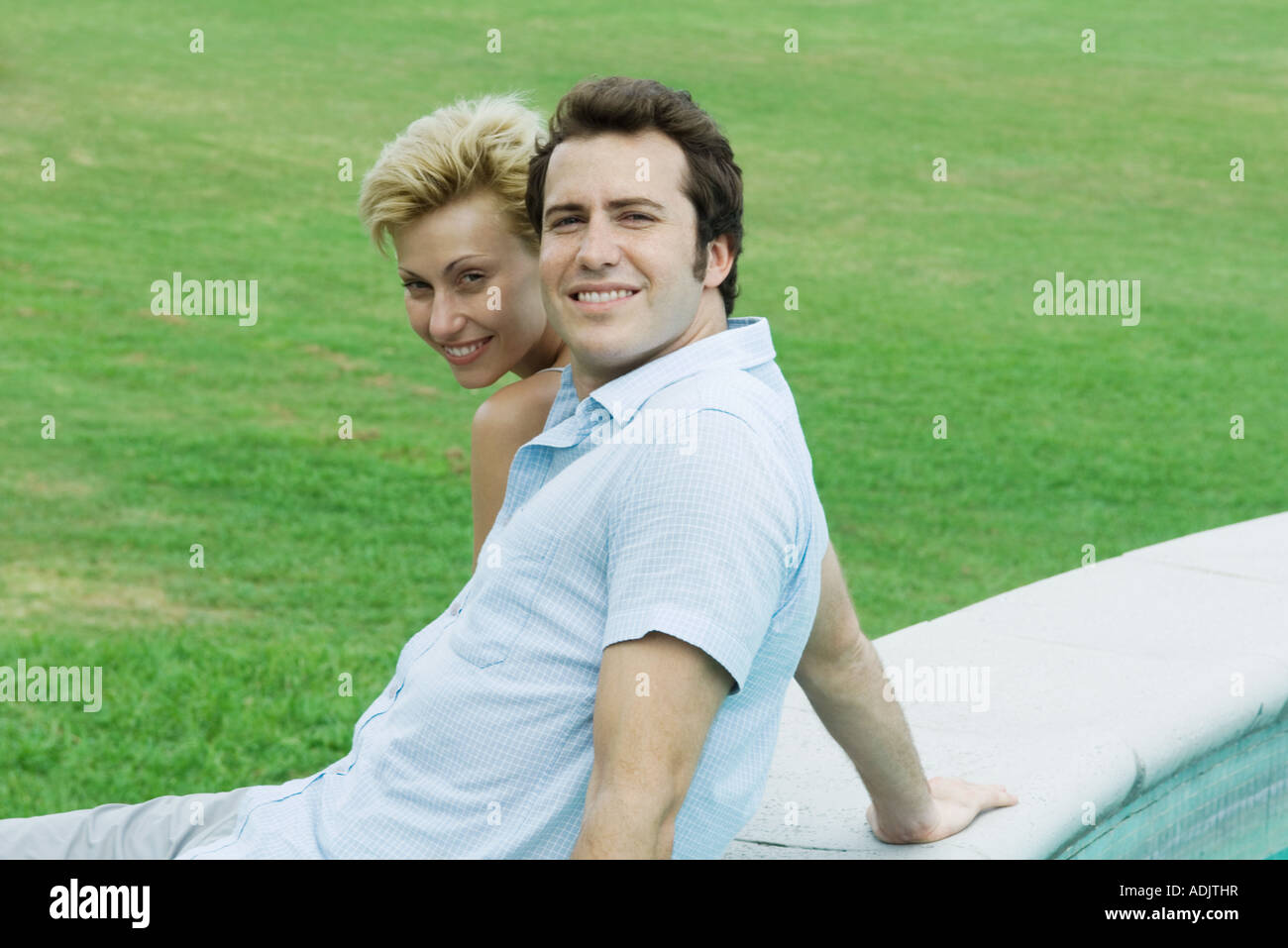Two couples sitting by swimming pool hi-res stock photography and ...