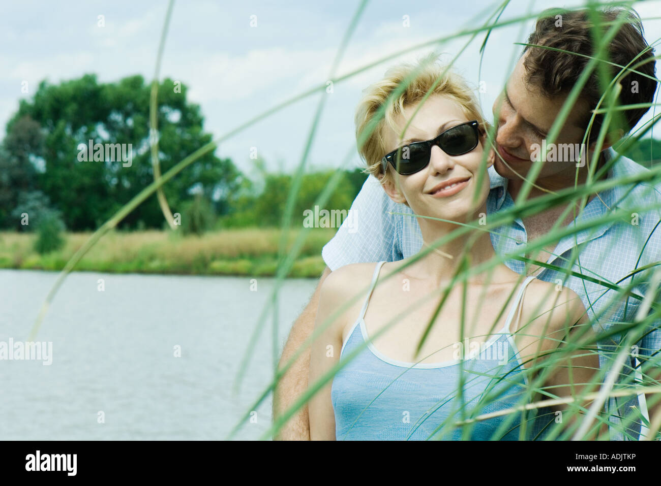 Couple, man looking over woman's shoulder, lake in background Stock ...