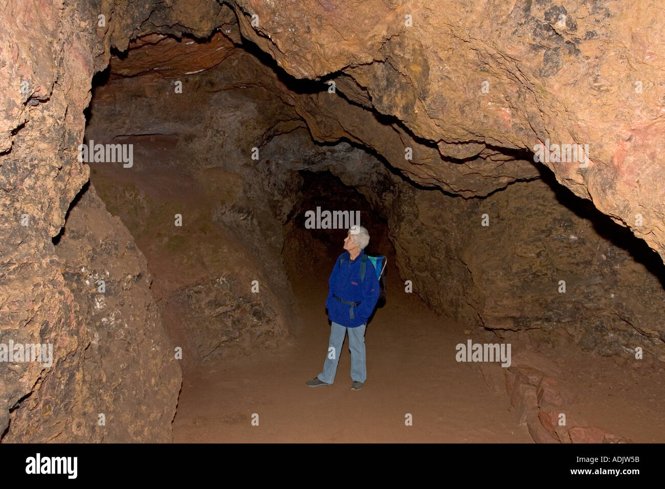 Visitor exploring large cavern in Clearwell caves in the Forest of Dean ...