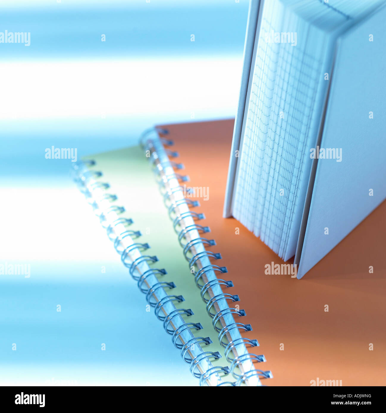 Notebooks with spring and a book standing Stock Photo - Alamy