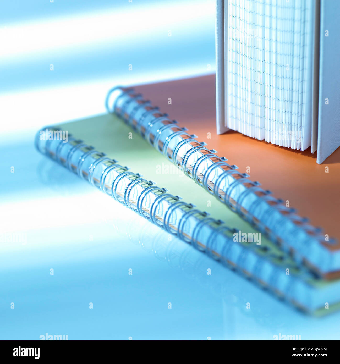 Notebooks with spring and a book standing Stock Photo - Alamy
