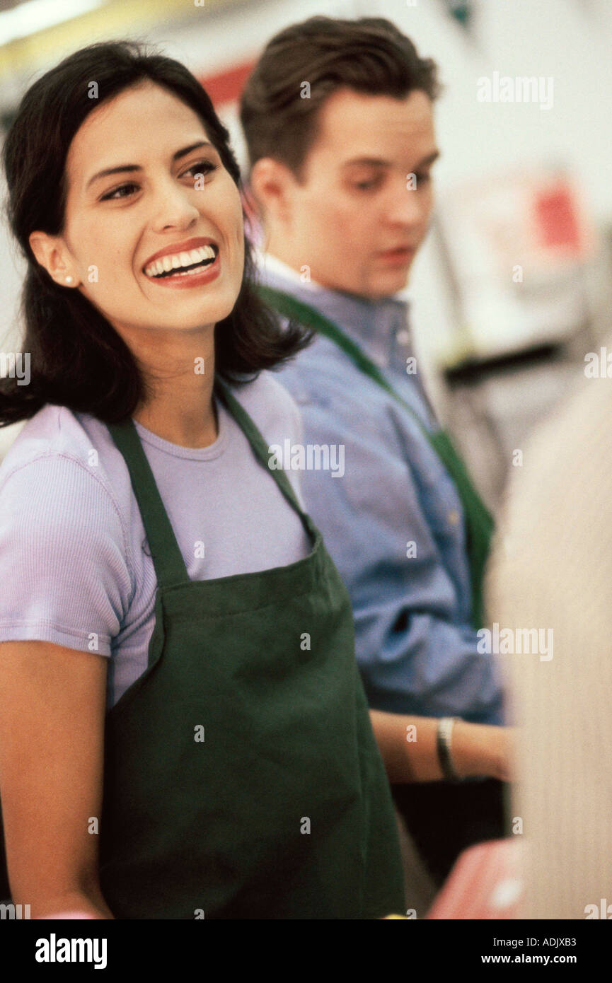 Female sales clerk standing at a checkout counter in a supermarket ...