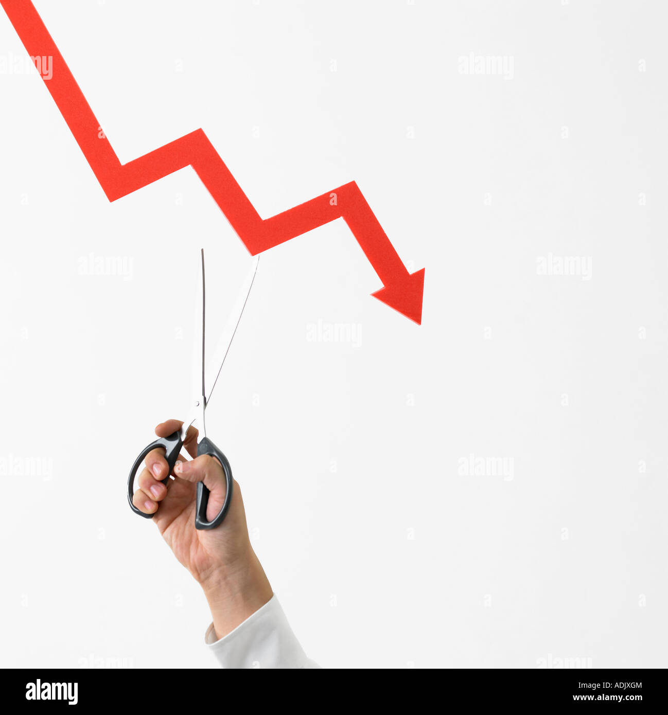 A hand cutting an arrow with scissors Stock Photo - Alamy