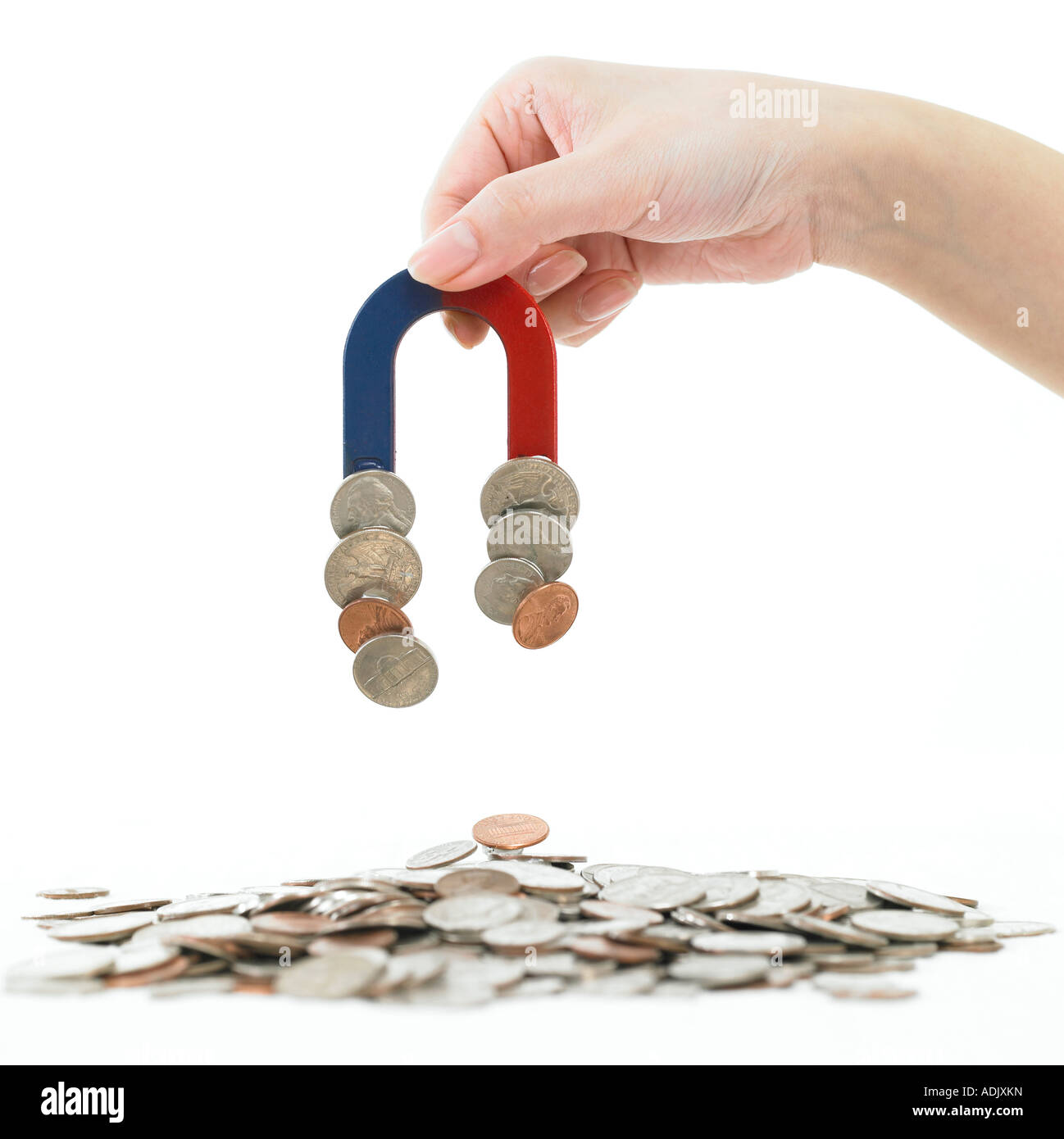 A woman's hand sticking coins on the magnet Stock Photo - Alamy